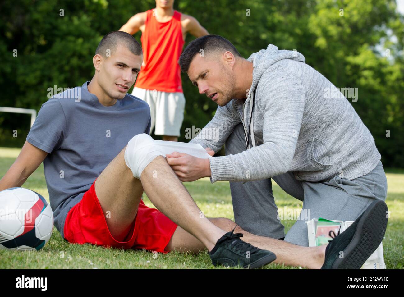 injured soccer player with ball on football field Stock Photo - Alamy