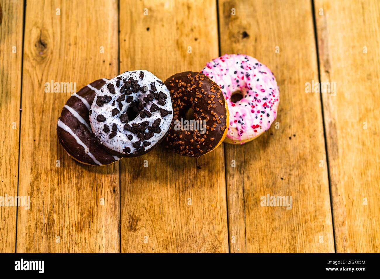 Colorful donuts on wooden table. Sweet icing sugar food with glazed ...