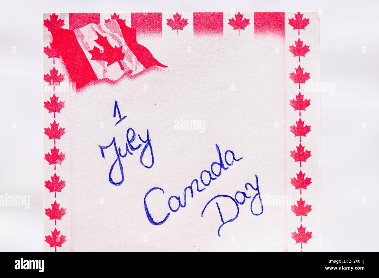 Canada day 1 July handwriting on paper with Canada flag. Writing text ...