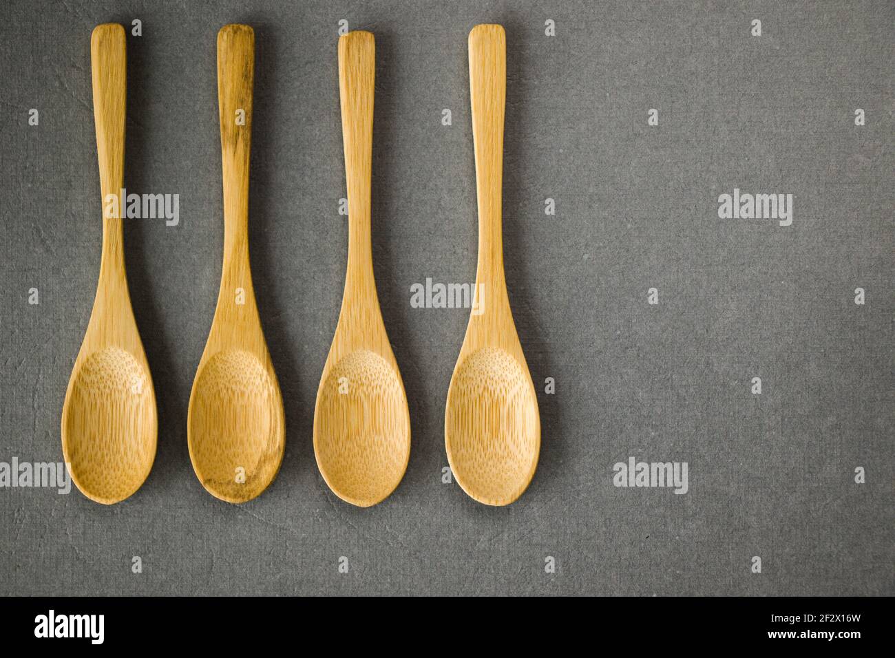A top view of several empty wooden spoons on the gray background ...