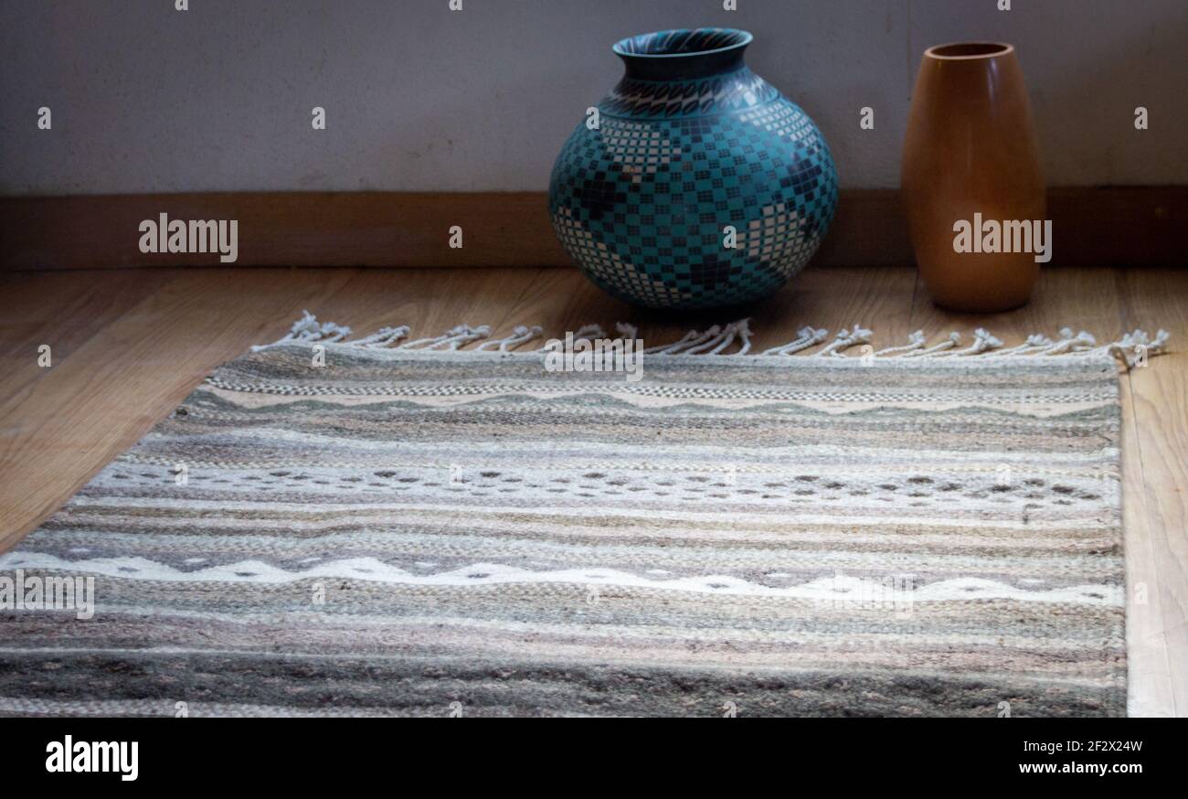 Photograph of a hand made wool textile and clay vase background or ...