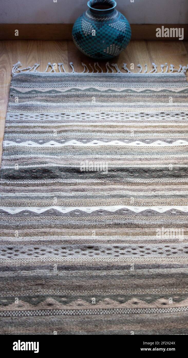Photograph of a hand made wool textile and clay vase background or ...