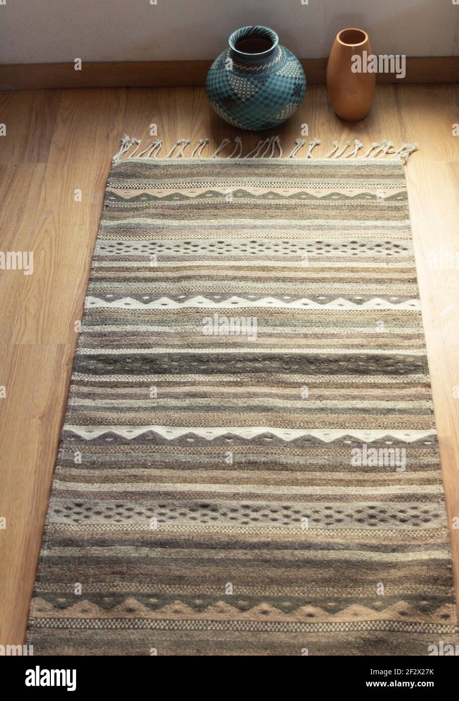 Photograph of a hand made wool textile and clay vase background or ...