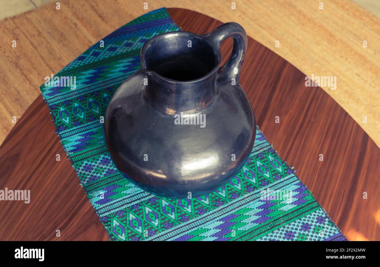 Photograph of a hand made wool textile and clay vase background or ...
