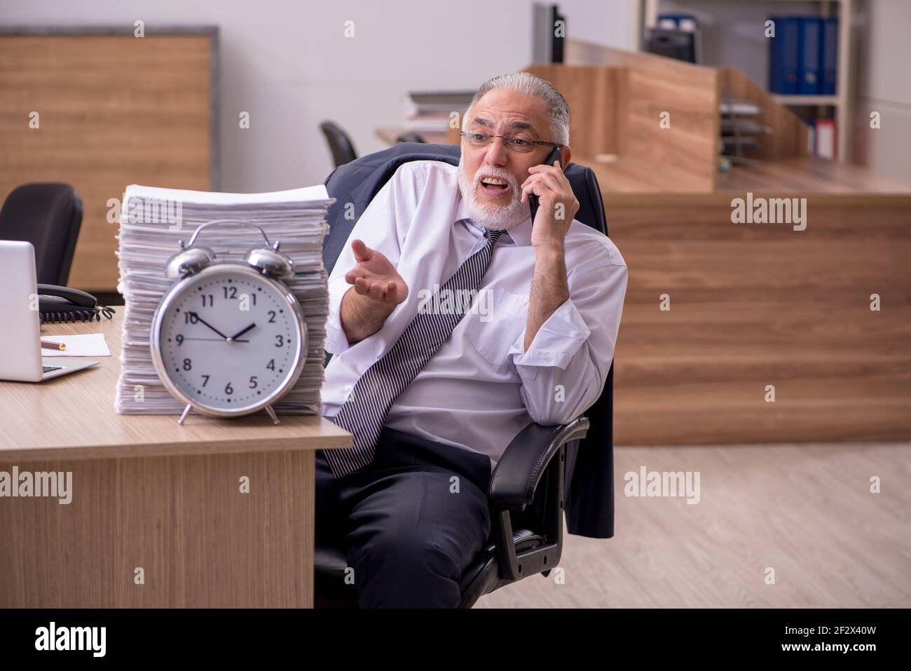 Old employee in time manegement concept Stock Photo - Alamy