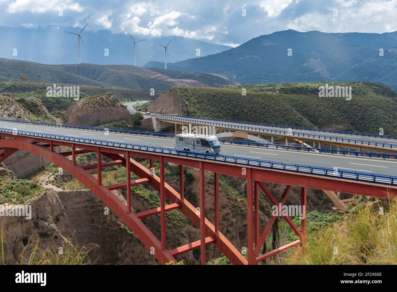 Landscape with a highway bridge with a motorhome driving, and mountains ...