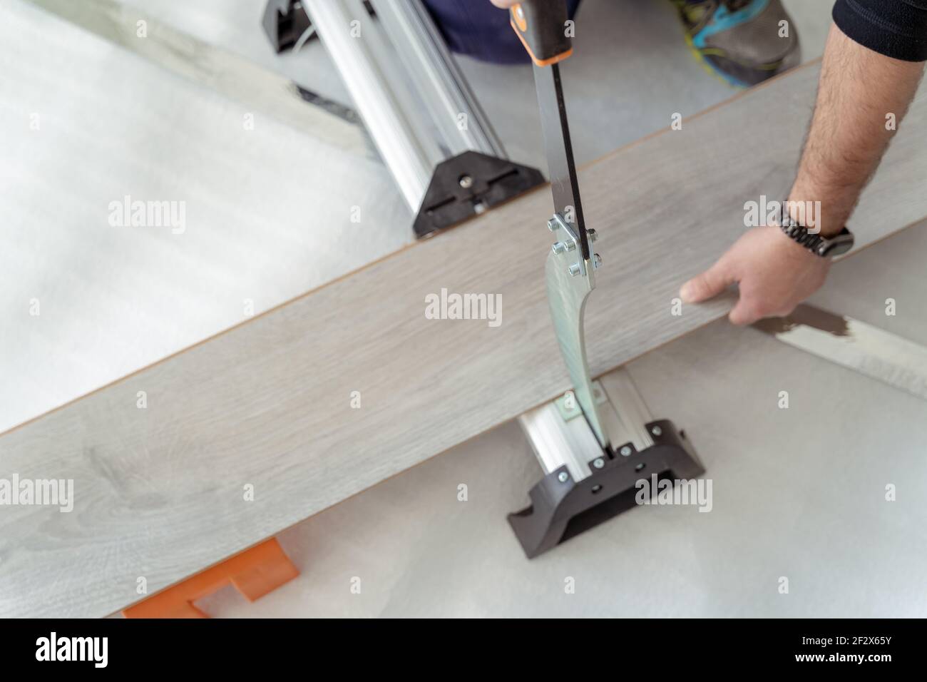 top view of a man cutting a sheet of wood with a guillotine for the ...
