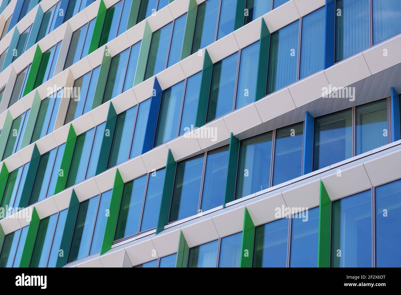 Modern quadratic building detail with windows of blue and green ...