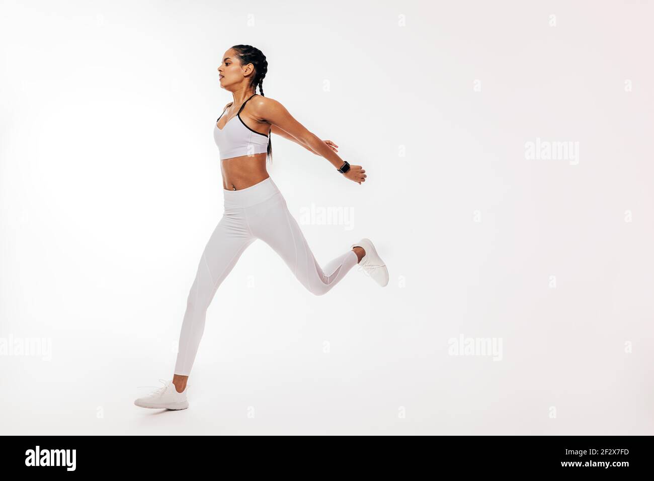 Young mixed race woman running over white background Stock Photo - Alamy