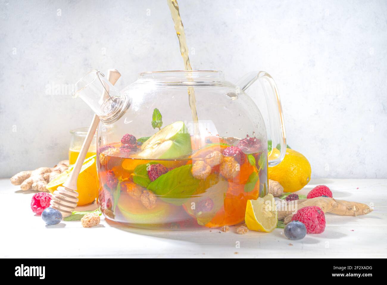 Fruit and berry tea in teapot. Hot drink with lemon, mint, blueberry ...