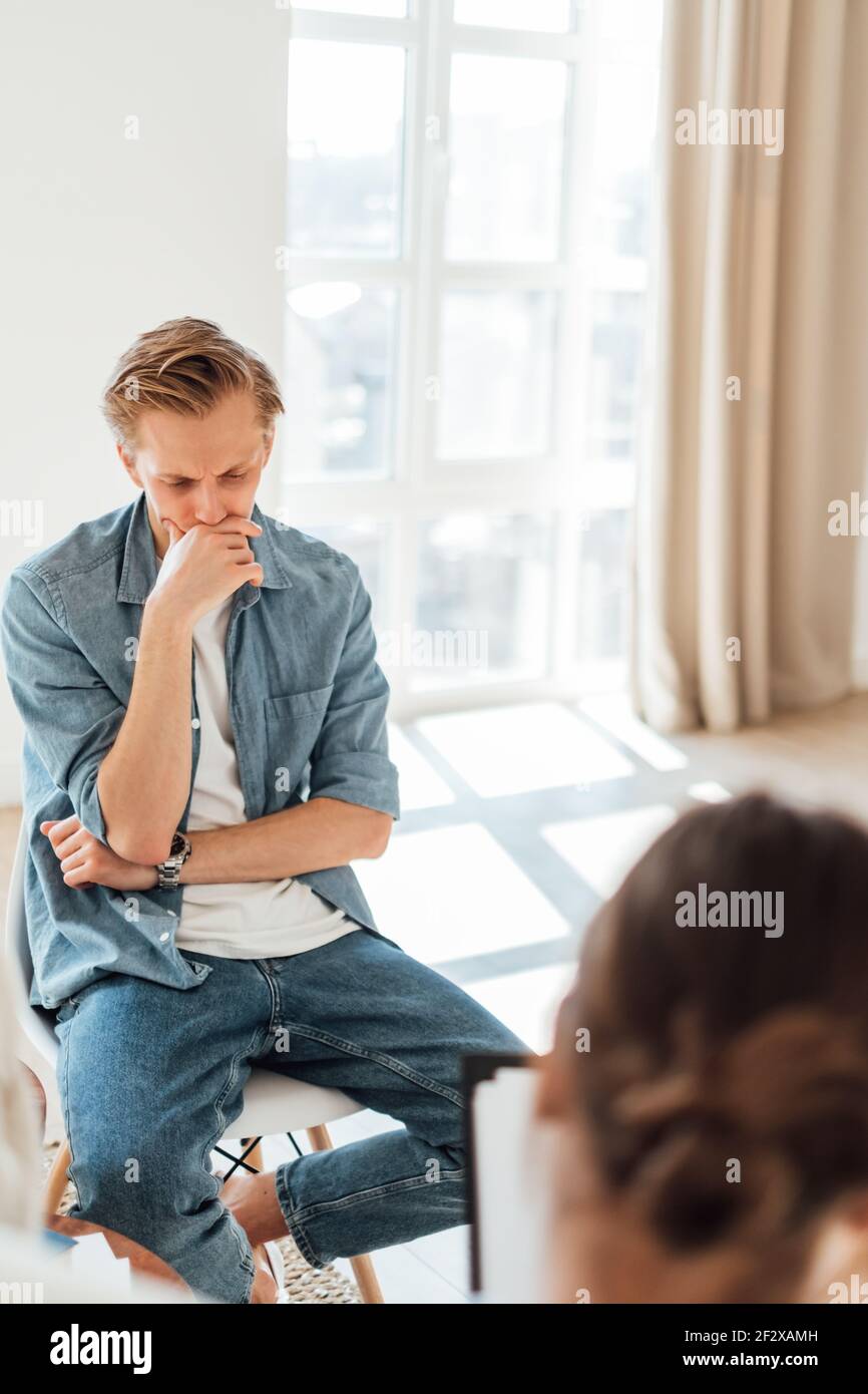 Upset caucasian man communicating with his psychologist, at a ...