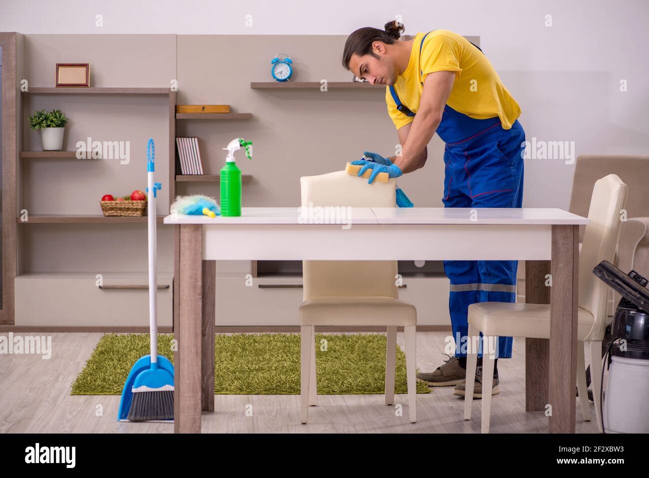 Young contractor cleaning the house Stock Photo - Alamy