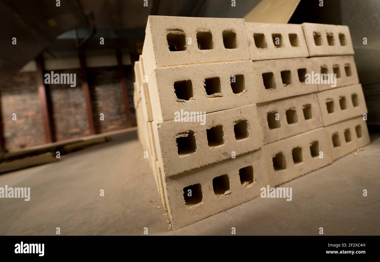 Small stack of light beige bricks indoors. Low angle, slanted, closeup ...