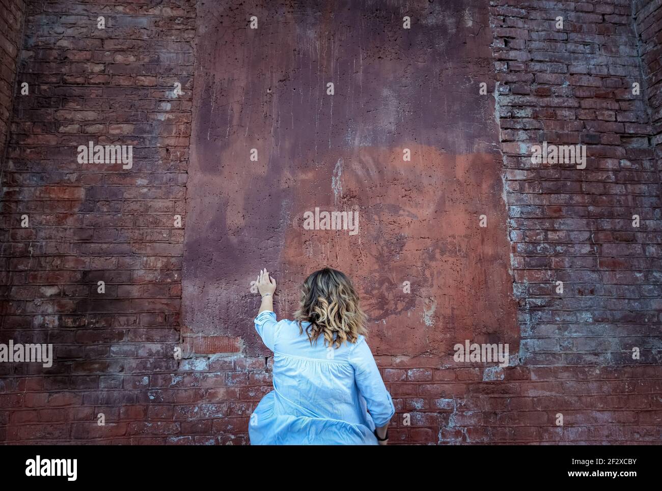 Woman back against wall hands hi-res stock photography and images - Alamy
