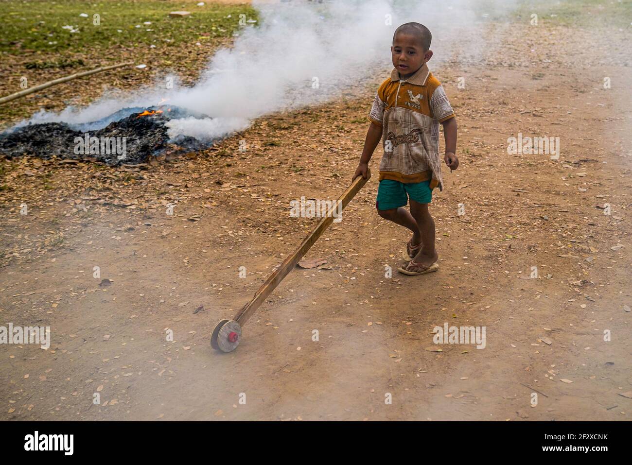 Dhaka, Bangladesh. 13th Mar, 2021. A kid playing next to burning ...