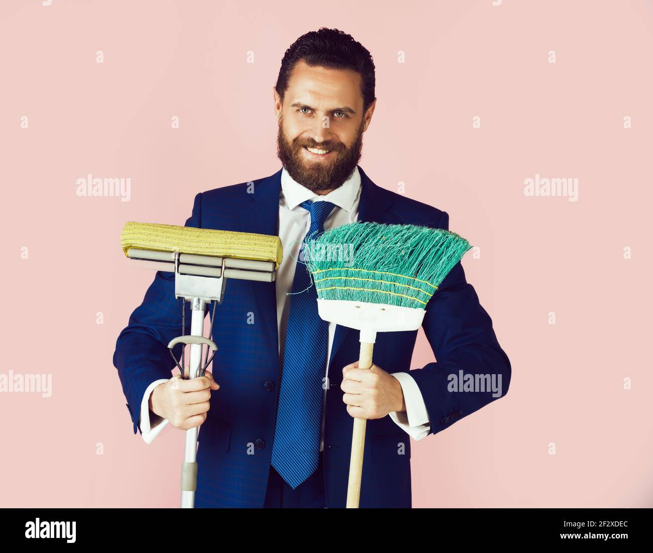 Funny businessman with happy smiling face holding broom in suit, pure ...