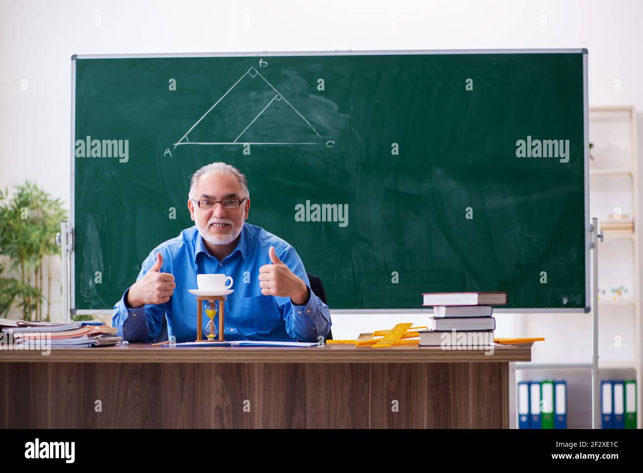 Senior male math teacher in time management concept Stock Photo - Alamy