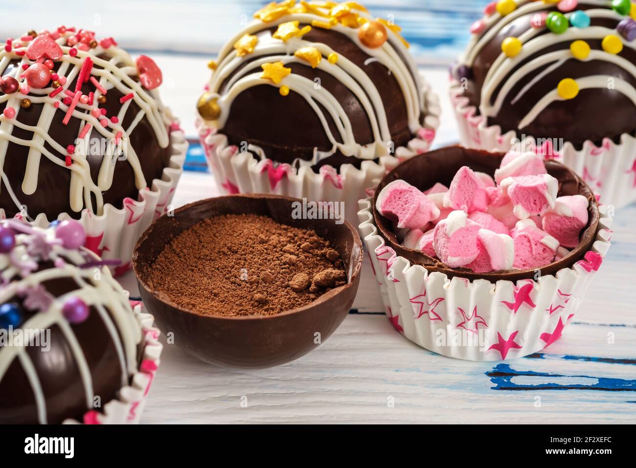 Cocoa bombs are black chocolate shells filled with cocoa powder and ...