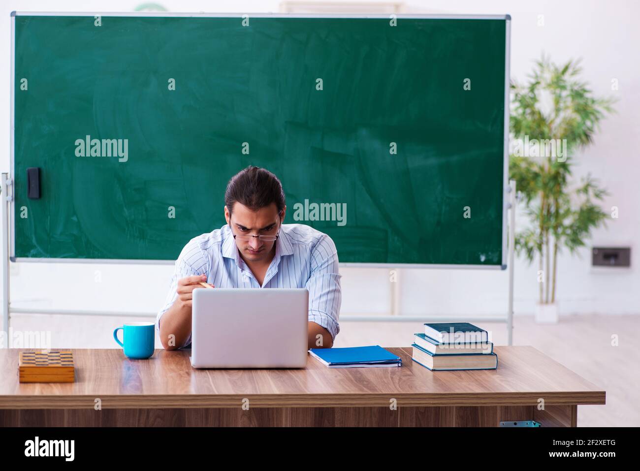 Young teacher in tele-education concept in the classroom Stock Photo ...