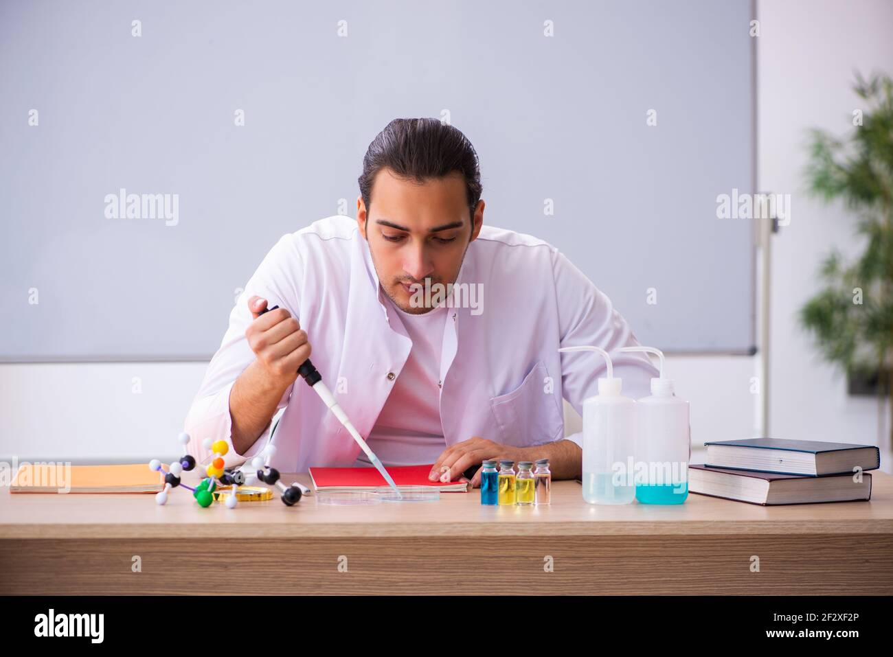 Young chemistry teacher in the classroom Stock Photo - Alamy
