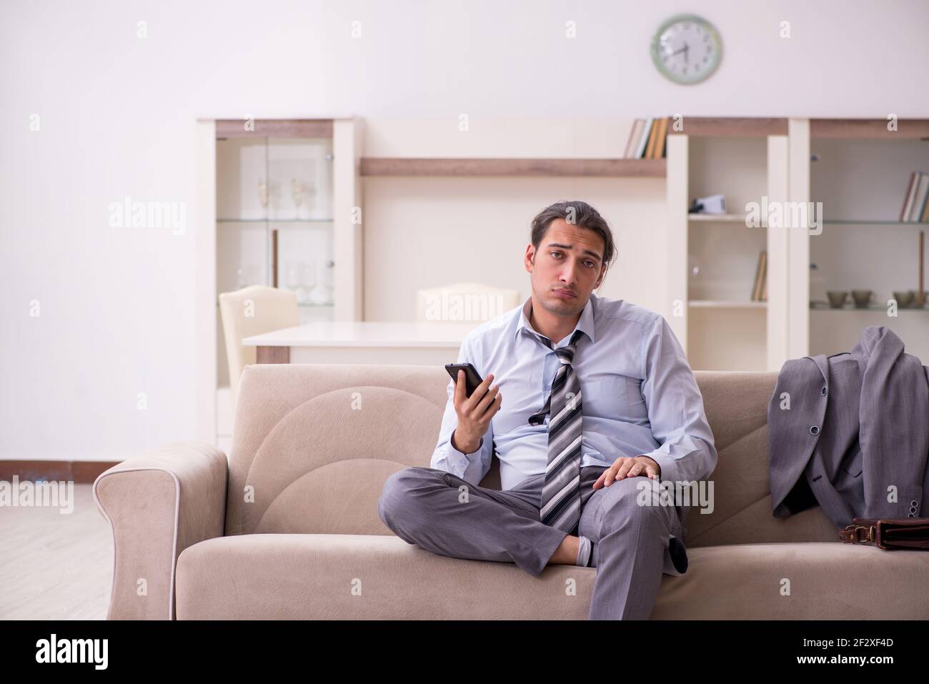 Tired businessman coming home after working day Stock Photo - Alamy