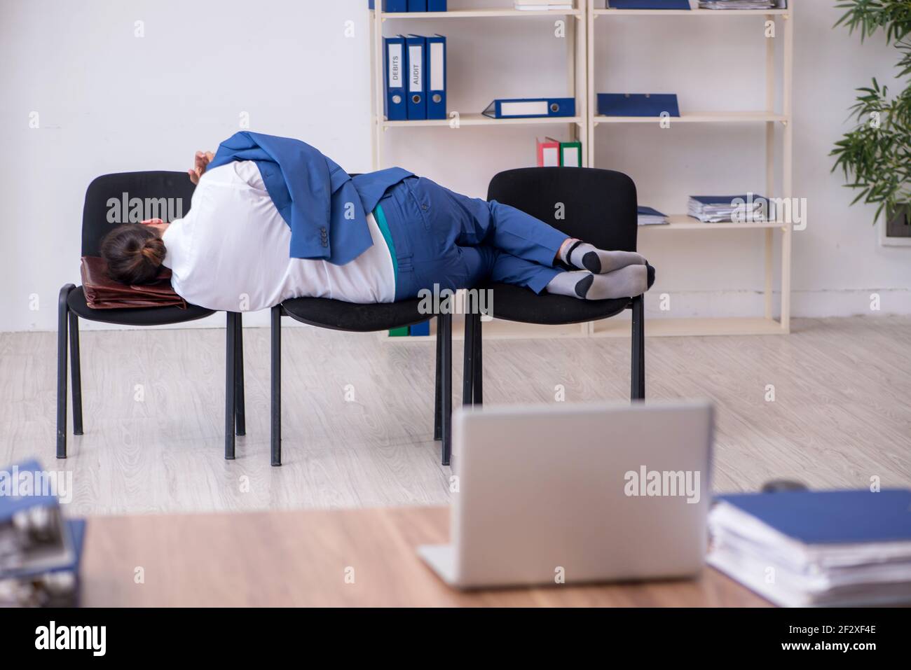 Young employee sleeping in the office on chairs Stock Photo - Alamy