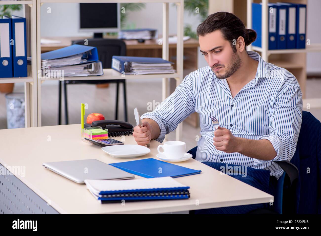 Hungry employee waiting for food at workplace Stock Photo - Alamy
