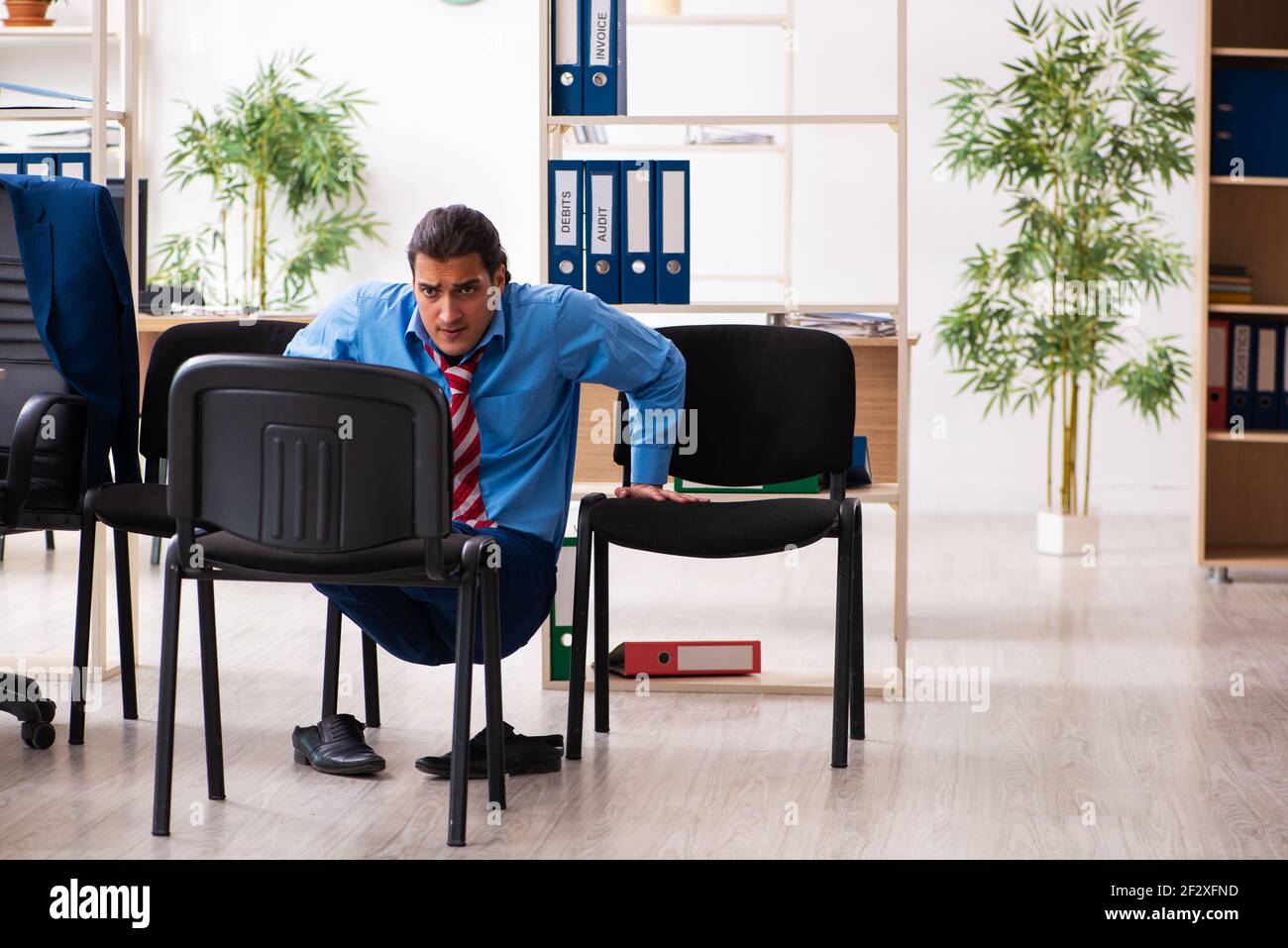Young businessman doing sport exercises at workplace Stock Photo - Alamy