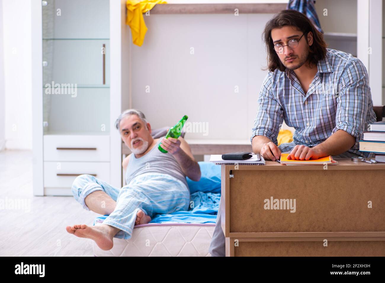 Young son student and dad alcoholic at home Stock Photo - Alamy