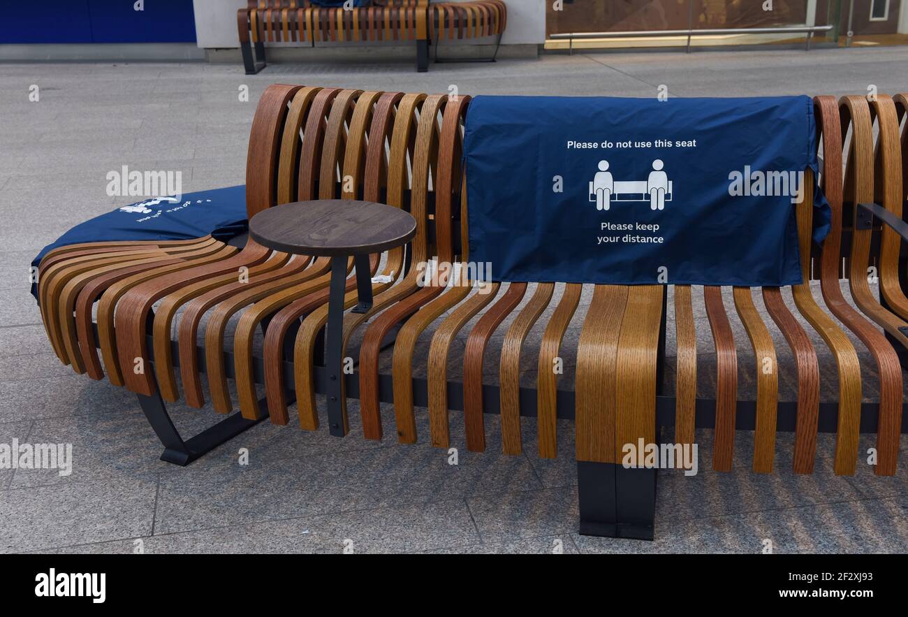 Wooden benches with blue notice sign please do not use this seat, keep ...