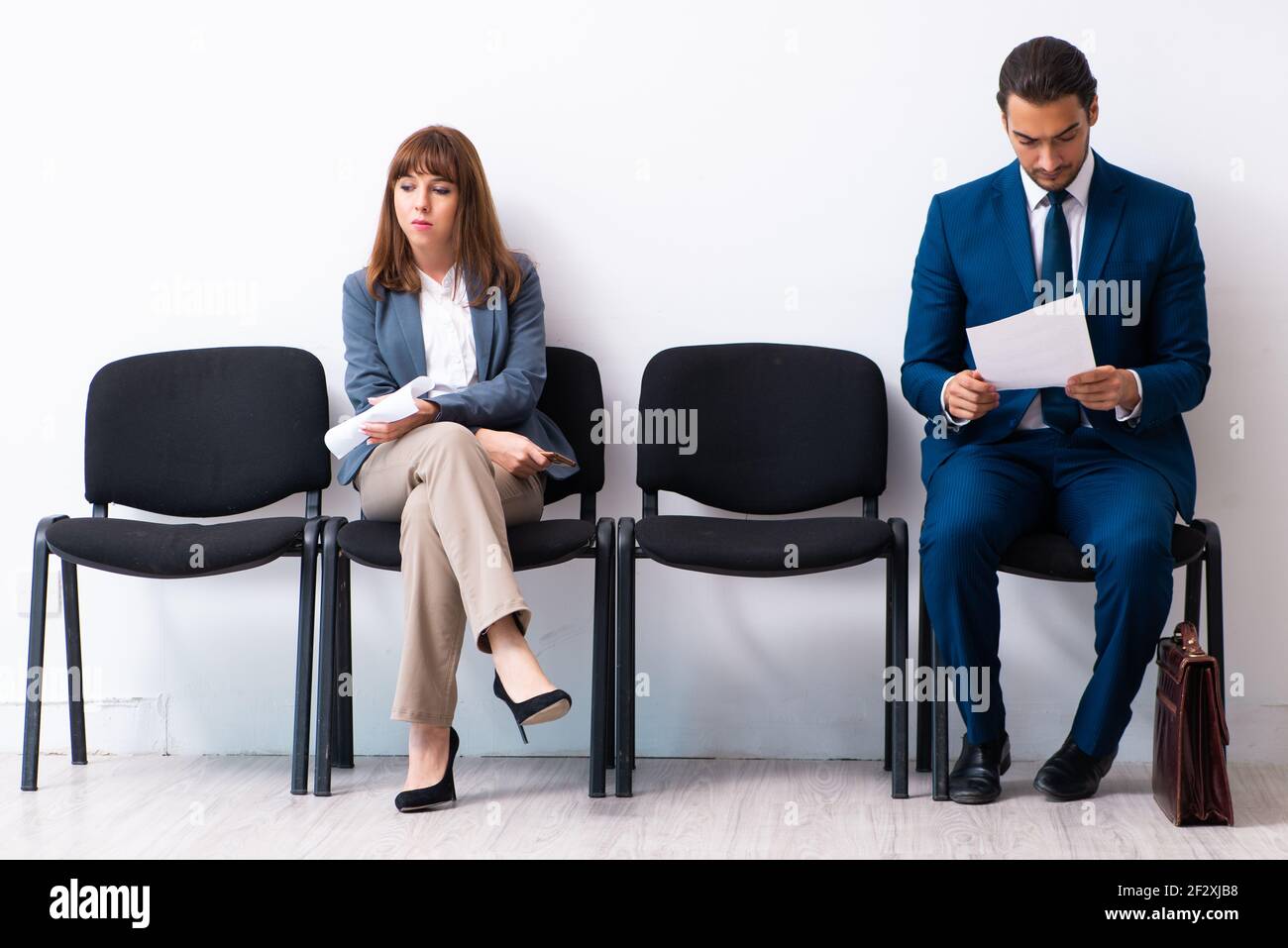 Businessman and businesswoman waiting for an interview at hall Stock ...
