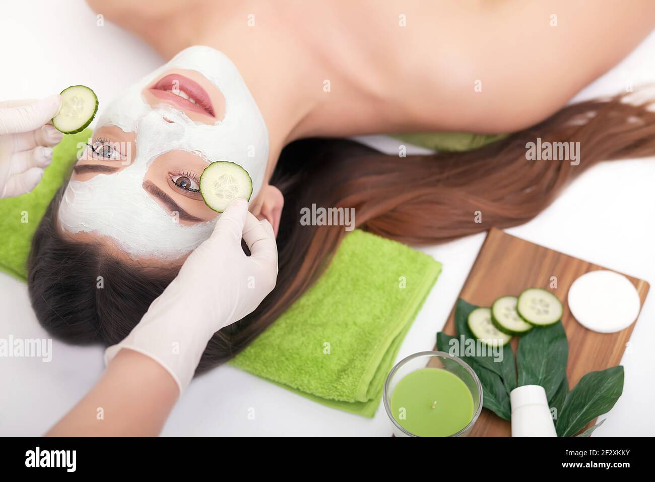 Applying facial mask at woman face on a white background Stock Photo ...