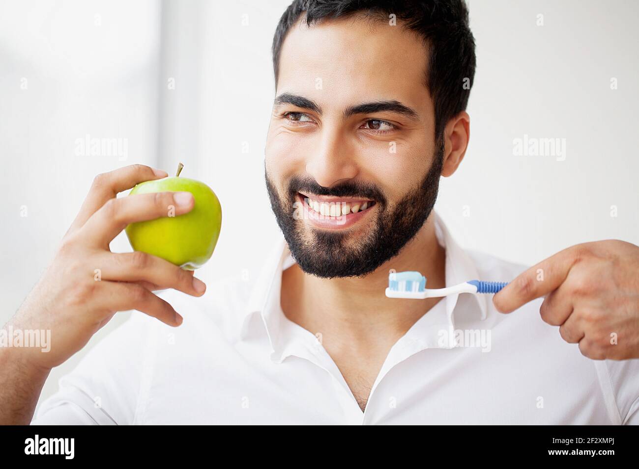 Man Eating Apple. Beautiful Girl With White Teeth Biting Apple. High ...