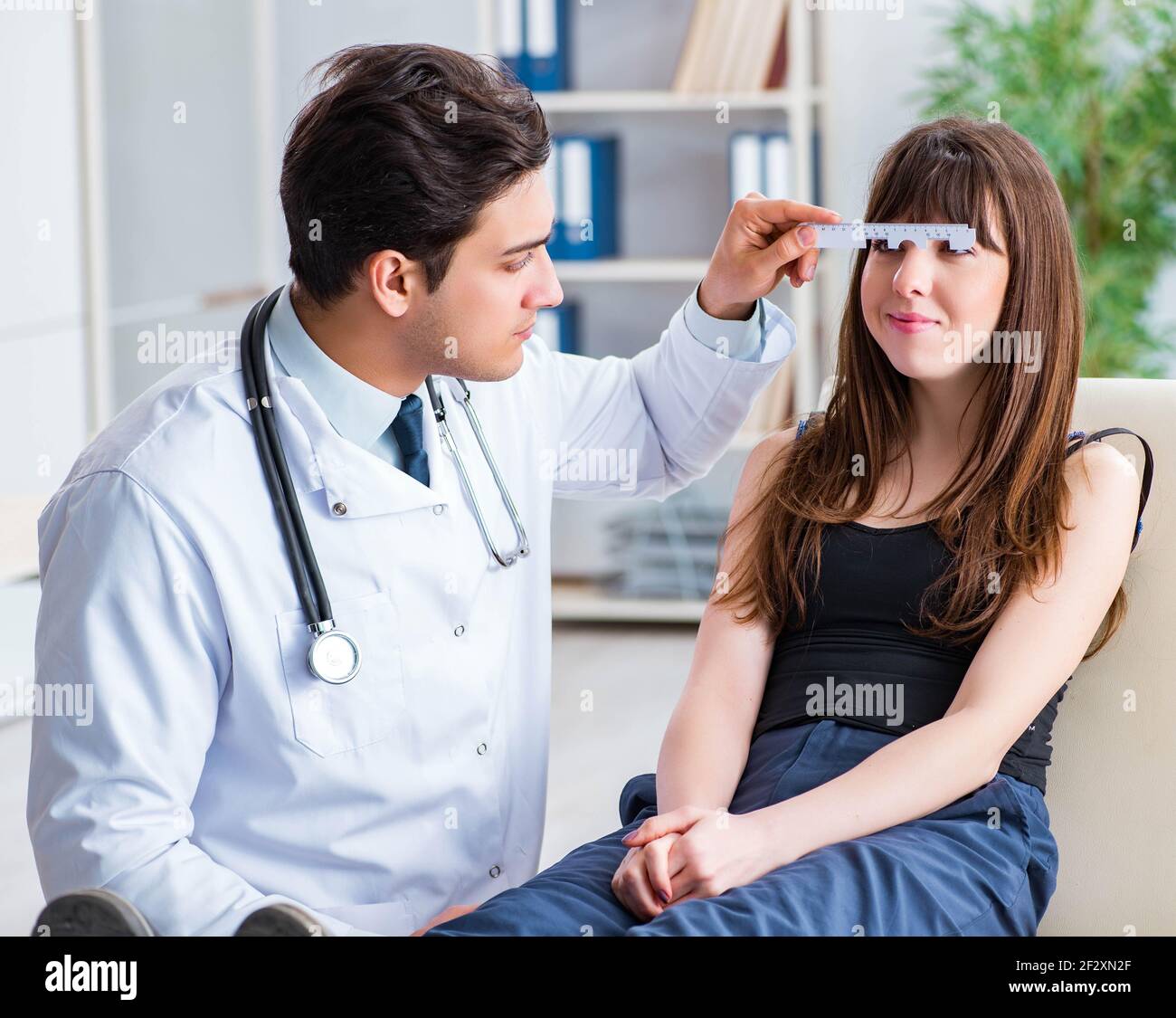 The ophthalmologist is checking up patient in eye doctor hospital Stock ...
