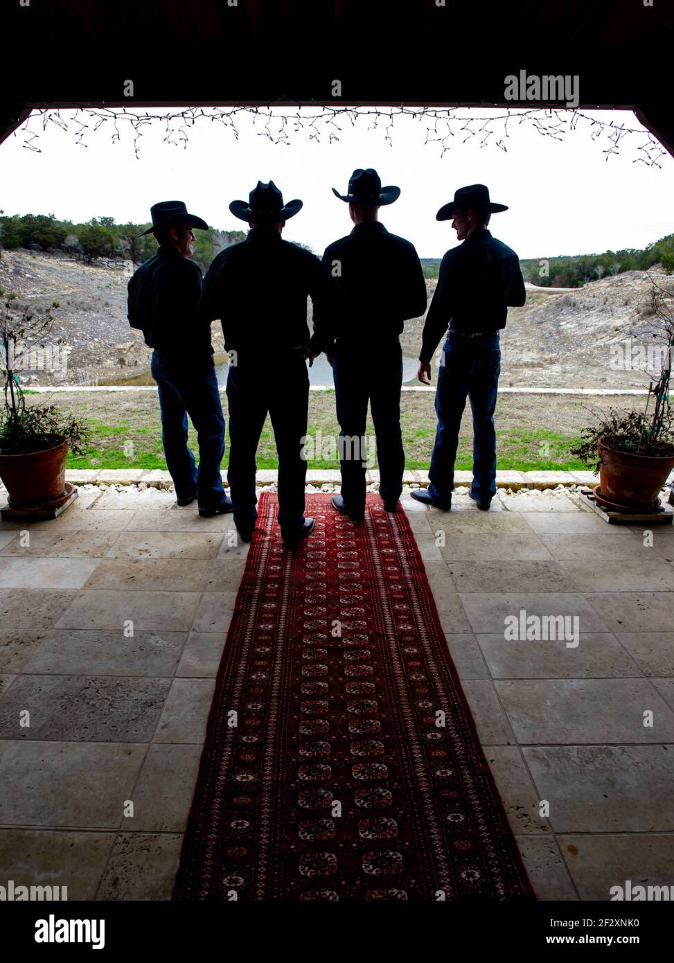 Four men in cowboy hats stand on a porch in silhouette at a Texas ranch Stock Photo - Alamy