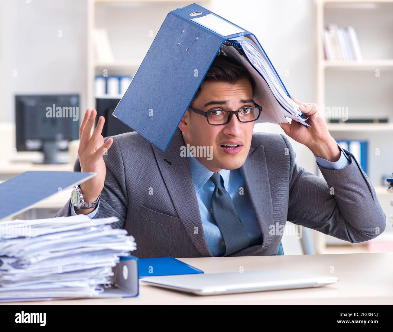 The overloaded with work employee under paperwork burden Stock Photo ...