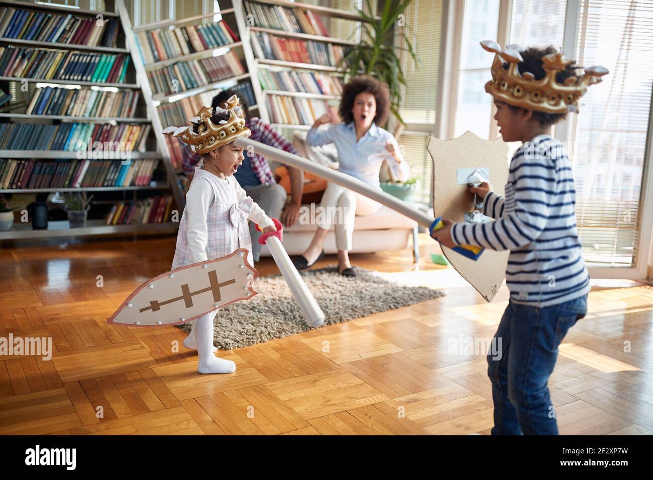 Kids playing with swords while parents cheering in a cheerful ...