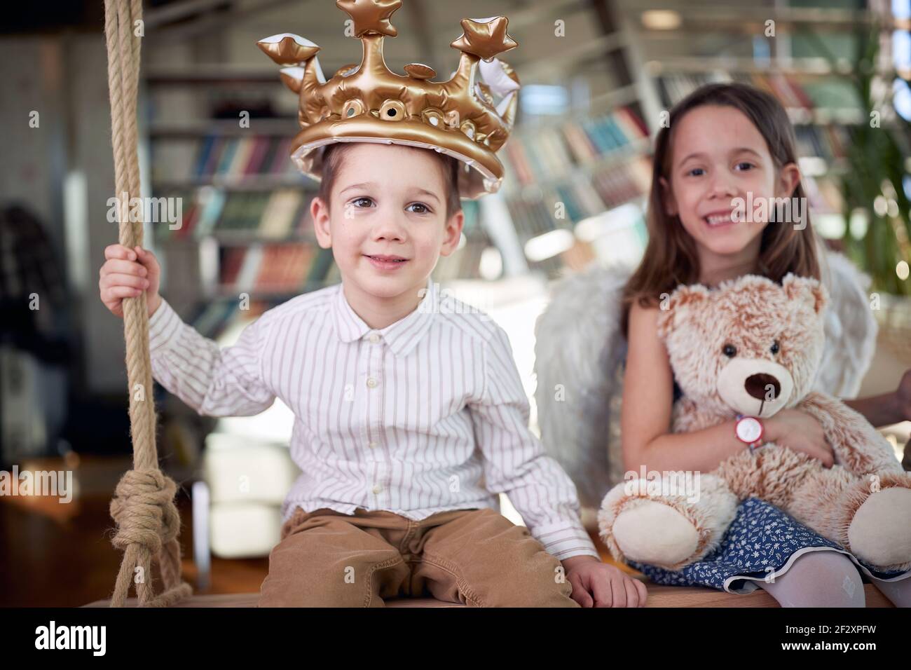 A little brother and sister enjoy posing for a photo while playing in a ...