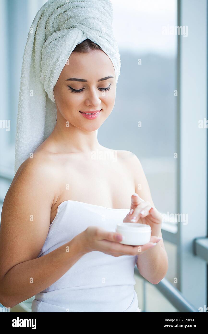 Skin care. Studio shot of beautiful young woman applying moisturizer ...