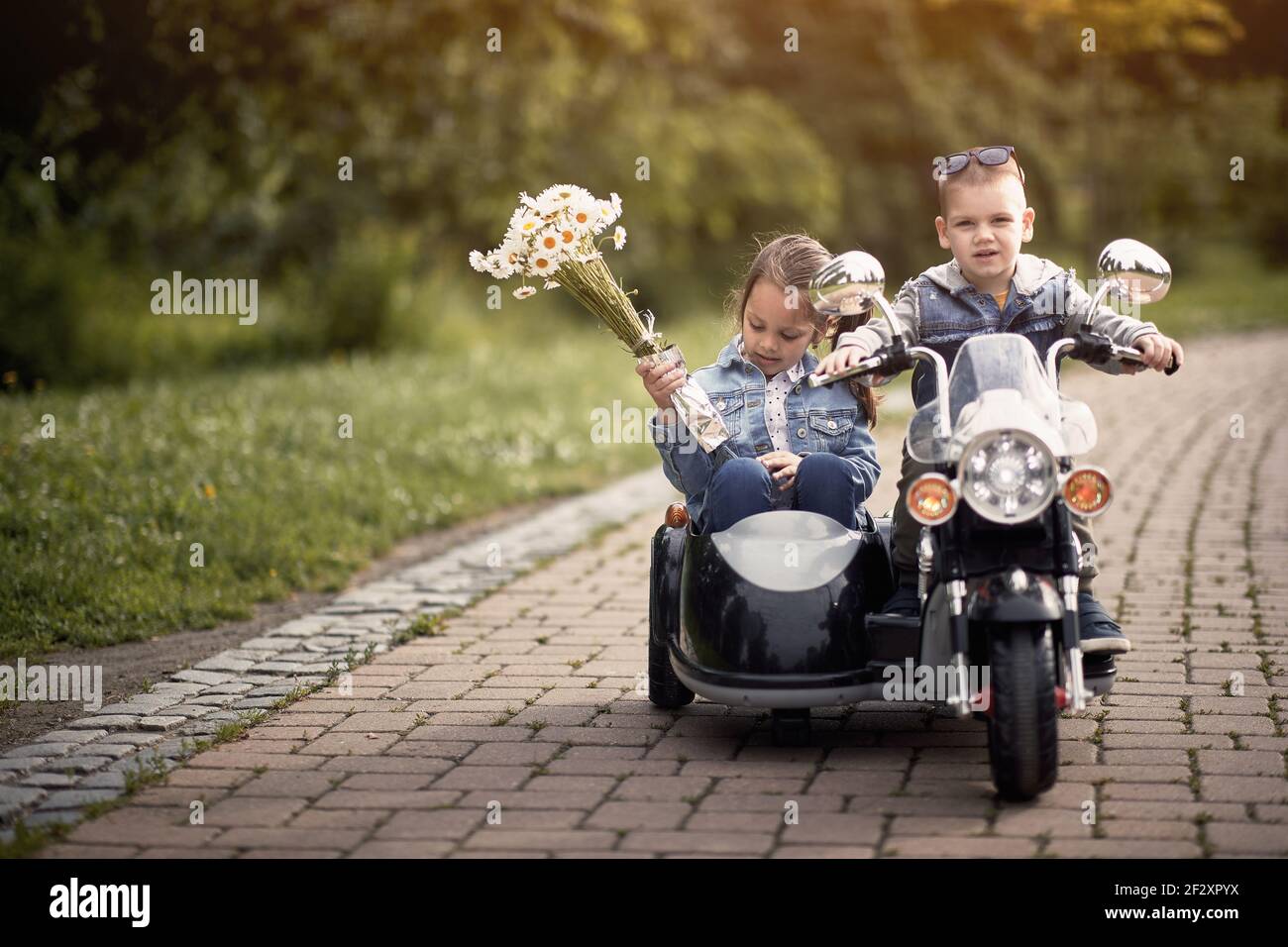 cute caucasian preschooler driving little girl in sidecar of motorcycle ...