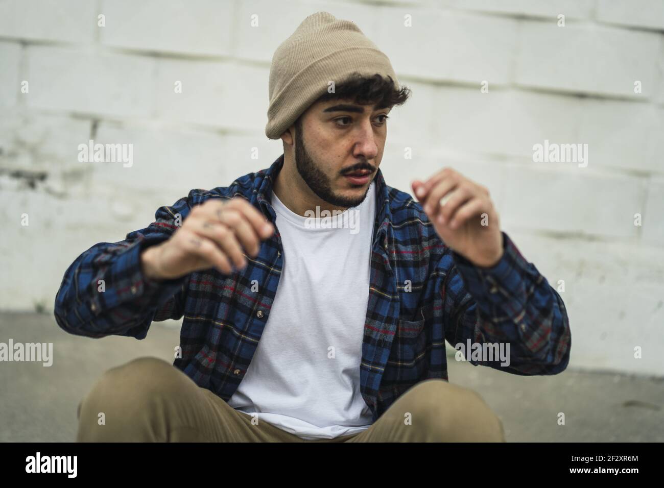 A cool Spanish male dressed casually on blurred wall background Stock ...