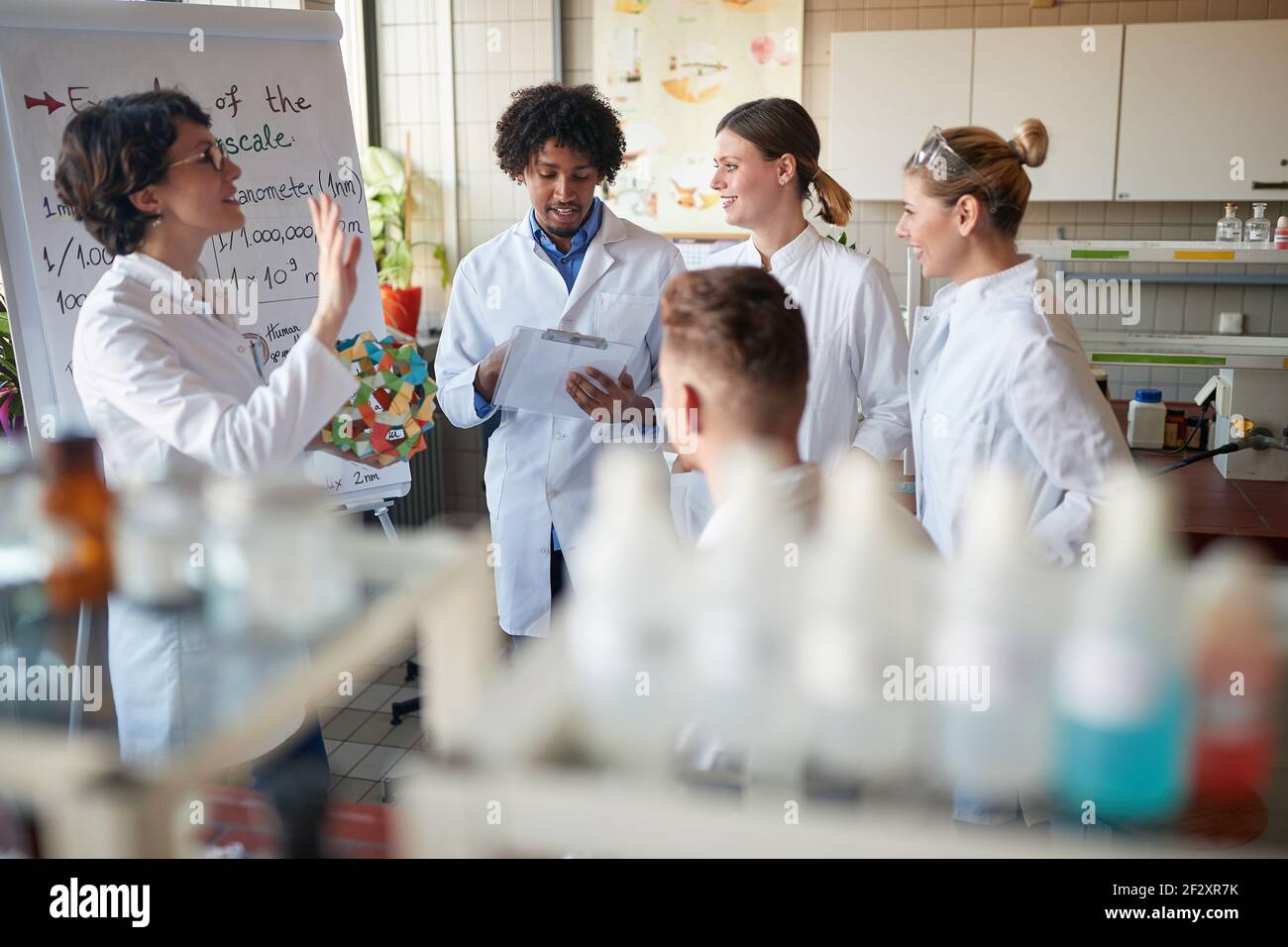 Young colleagues have a chemistry lesson in the university laboratory ...