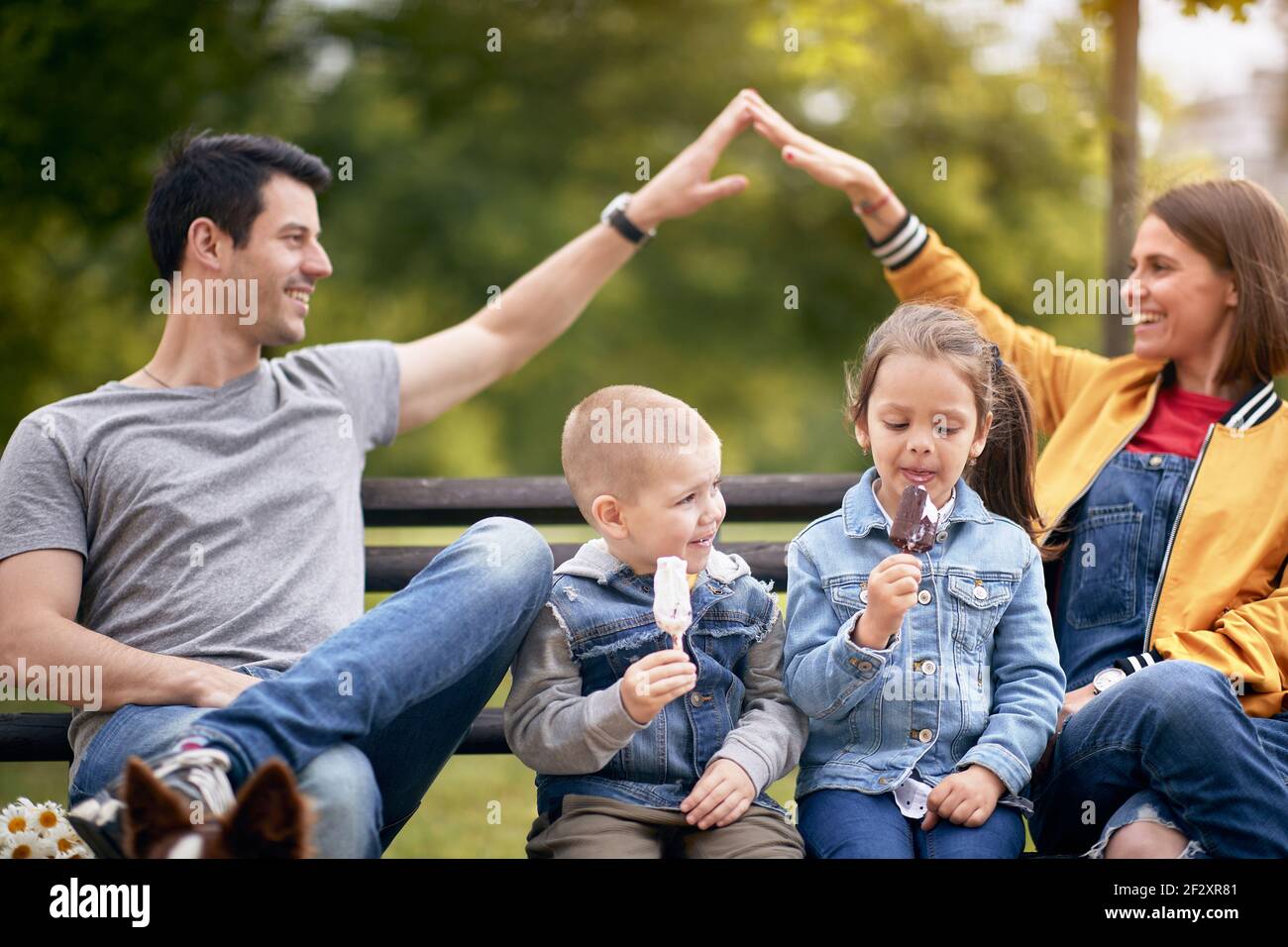 caucasian family of four having fun sitting on bench Stock Photo - Alamy
