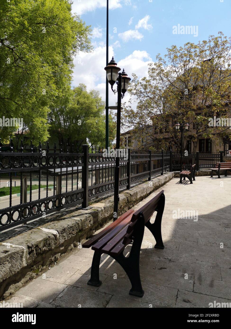 New wooden benches in a closed and isolated area with metallic fences ...