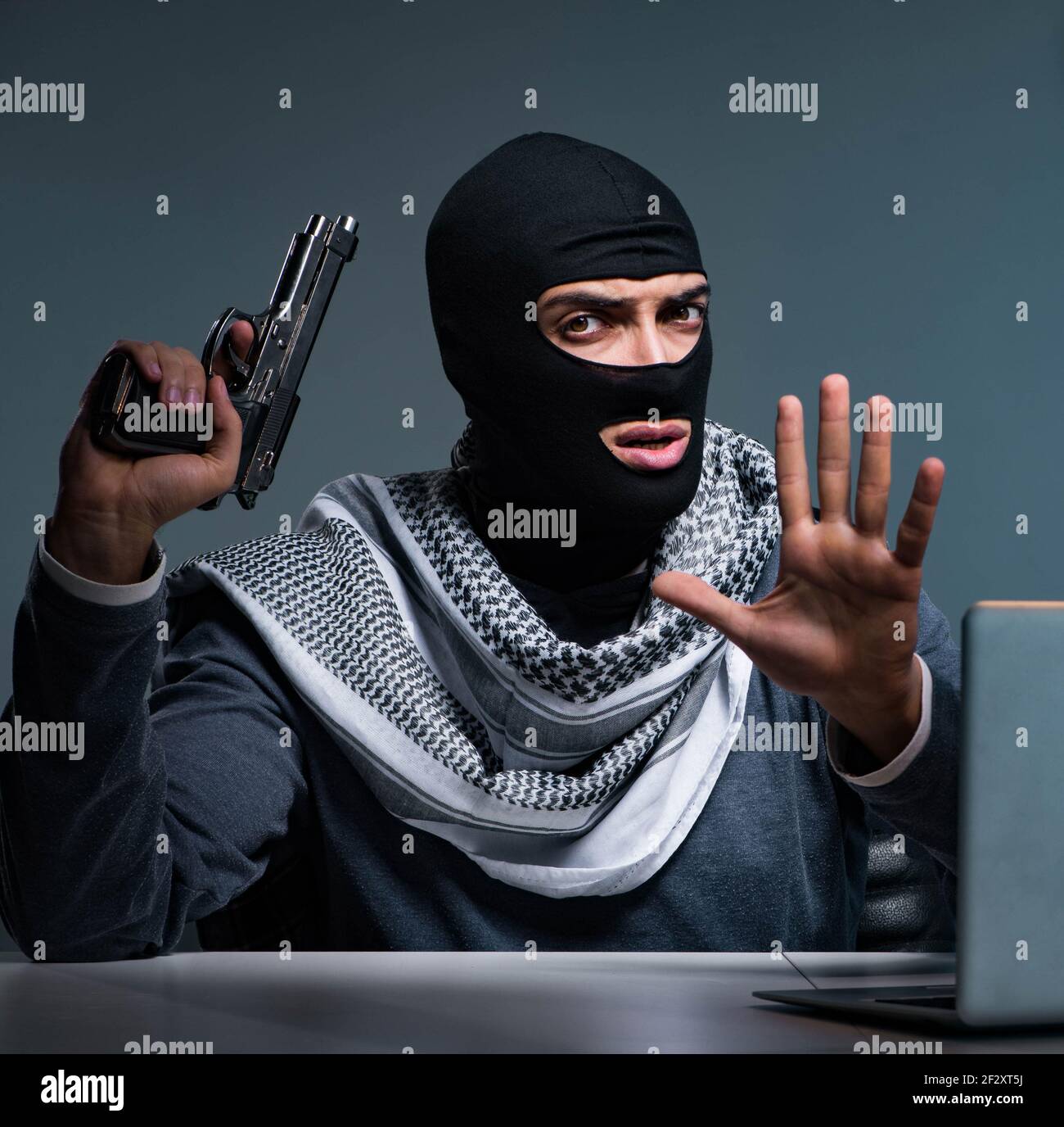 The terrorist burglar with gun working at computer Stock Photo - Alamy