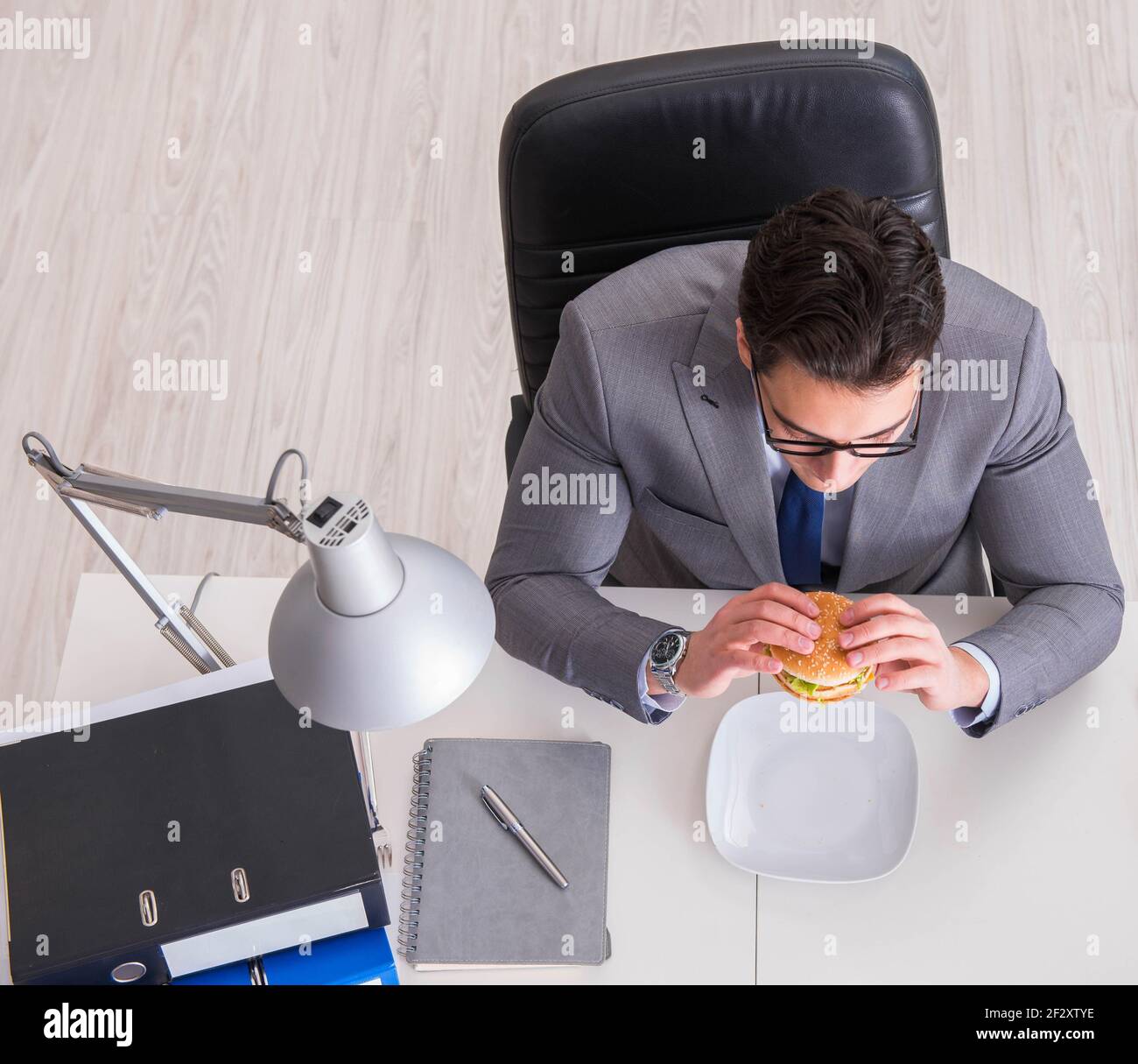 The hungry funny businessman eating junk food sandwich Stock Photo - Alamy