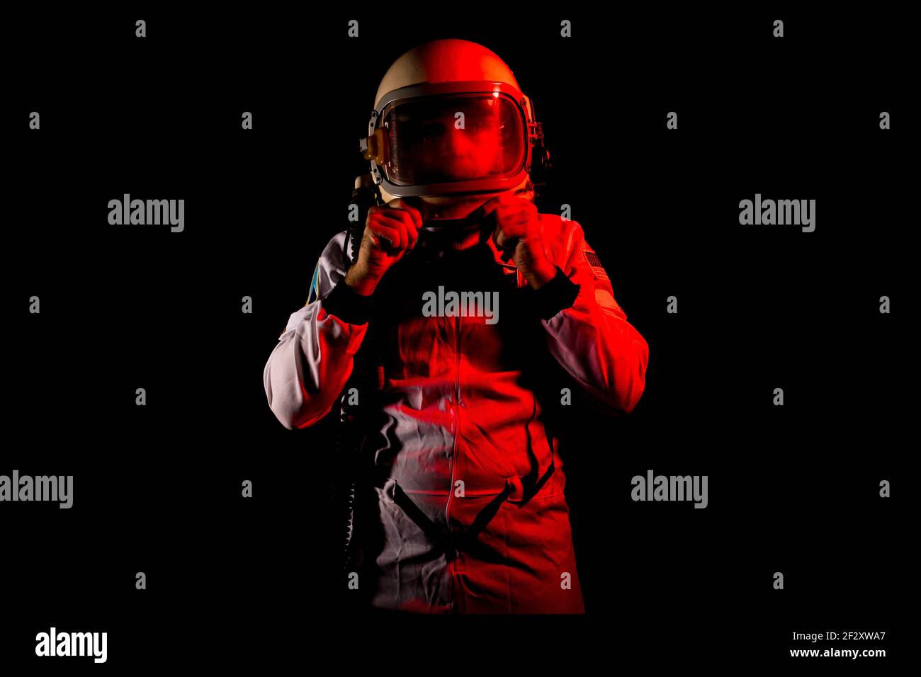 Male cosmonaut wearing white space suit and helmet while standing on ...