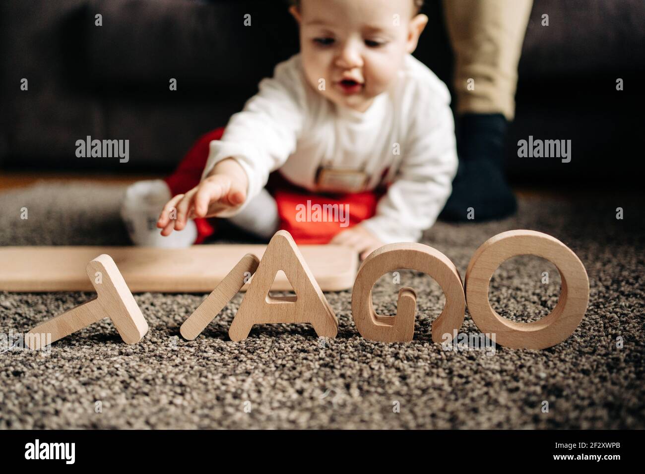 Adorable little baby playing on floor with wooden toy with Tiago name ...