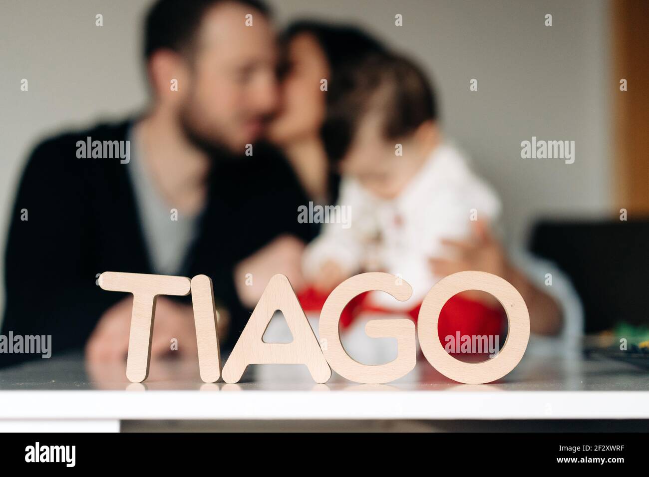 Wooden Tiago letter name placed on table near unrecognizable young ...