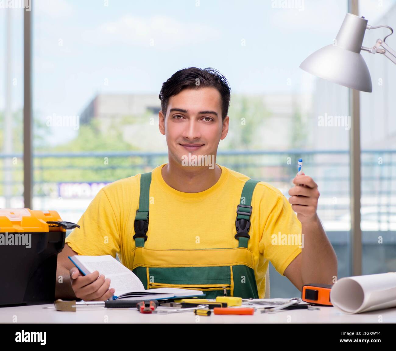 The construction worker sitting at the desk Stock Photo - Alamy